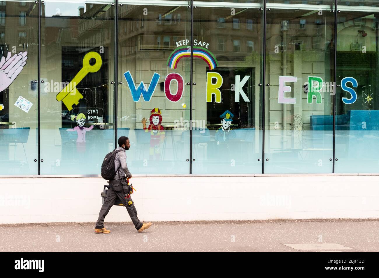 Electrician walking past Keep Safe Key Workers sign painted on the ...