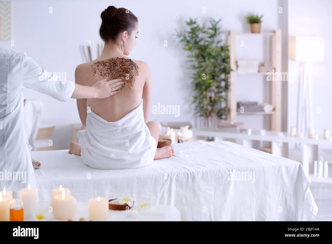 Beautiful young woman undergoing scrub treatment in spa salon Stock ...