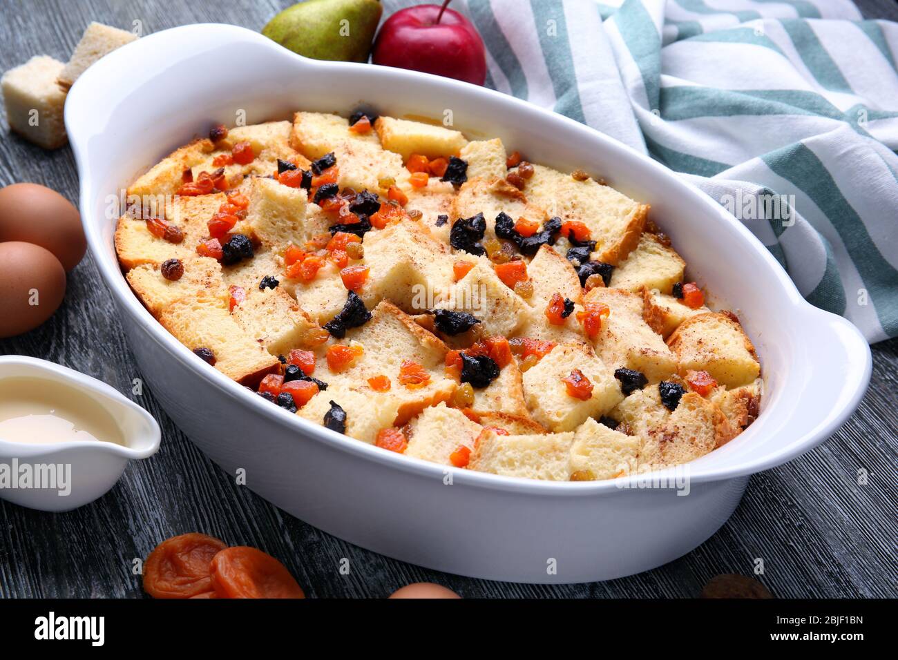 Freshly baked bread pudding in casserole dish on wooden table Stock ...