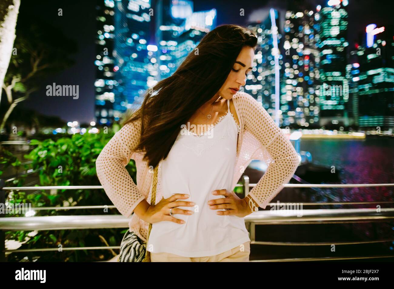 confused woman portrait standing outdoors at night street. upset woman ...