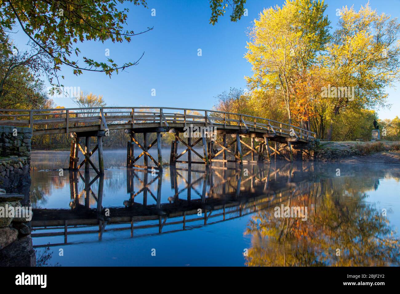 Autumn color in the maple trees at dawn over the Old North Bridge ...