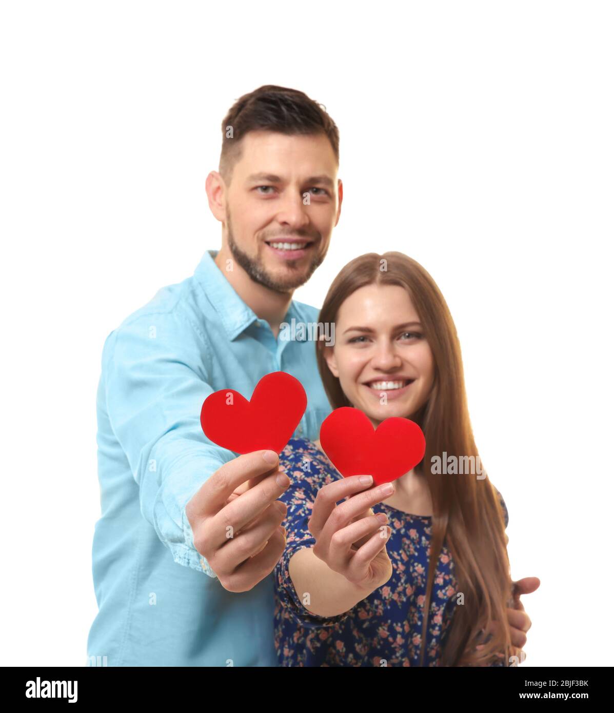 Happy young couple with red hearts on white background Stock Photo - Alamy