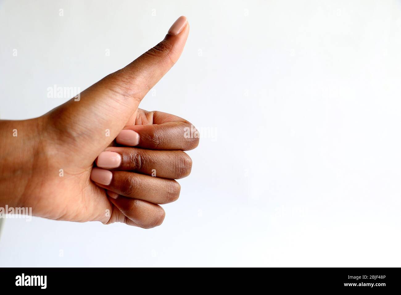 Isolated black african indian female hand giving a thumbs up signal ...