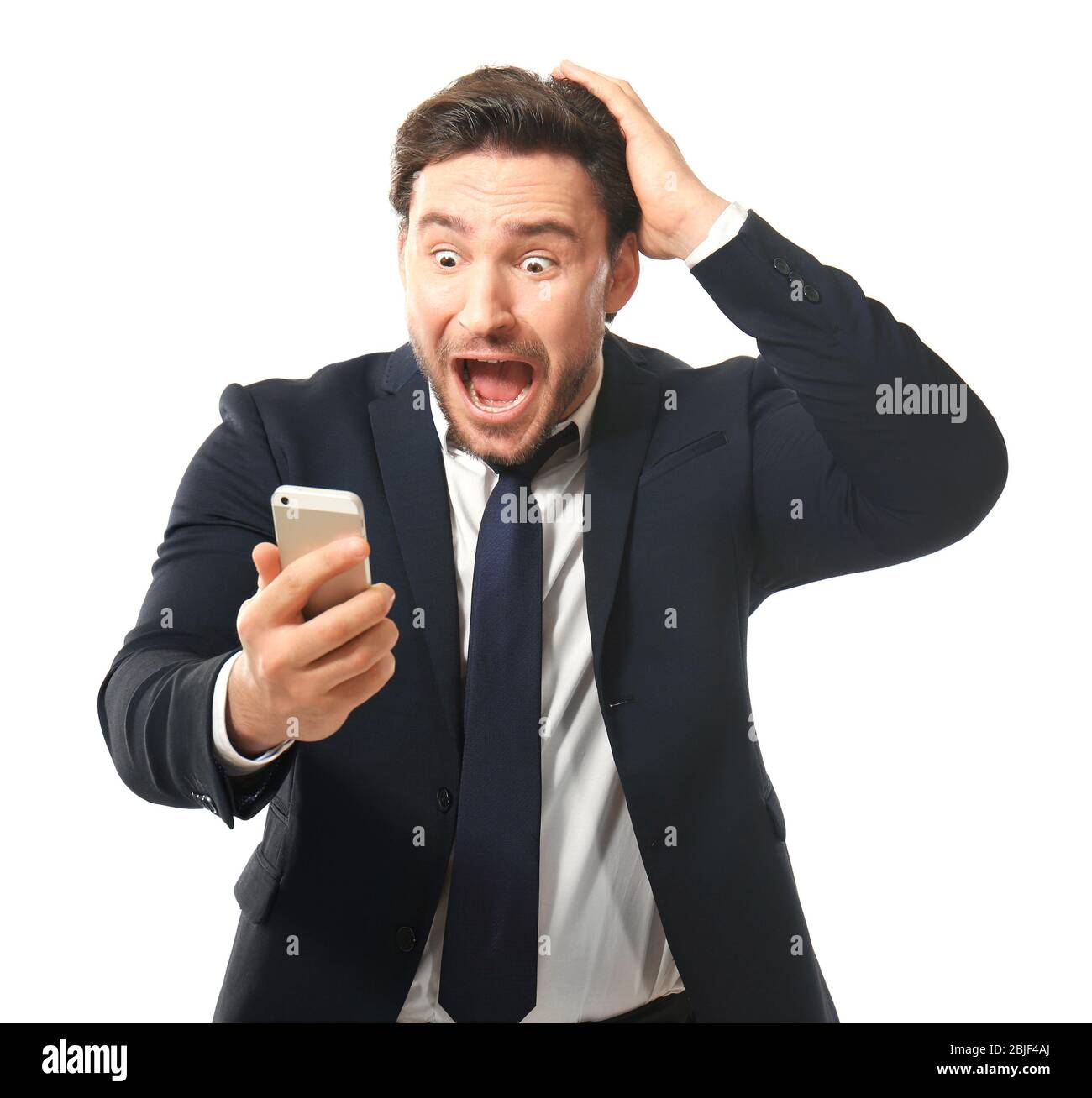 Handsome young man posing with phone on white background Stock Photo ...