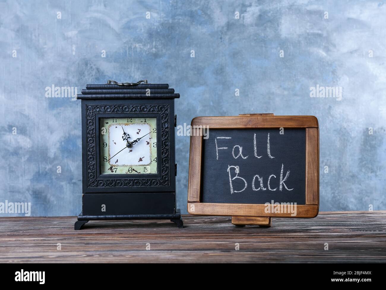 Chalkboard with text FALL BACK and retro clock on wooden table Stock ...
