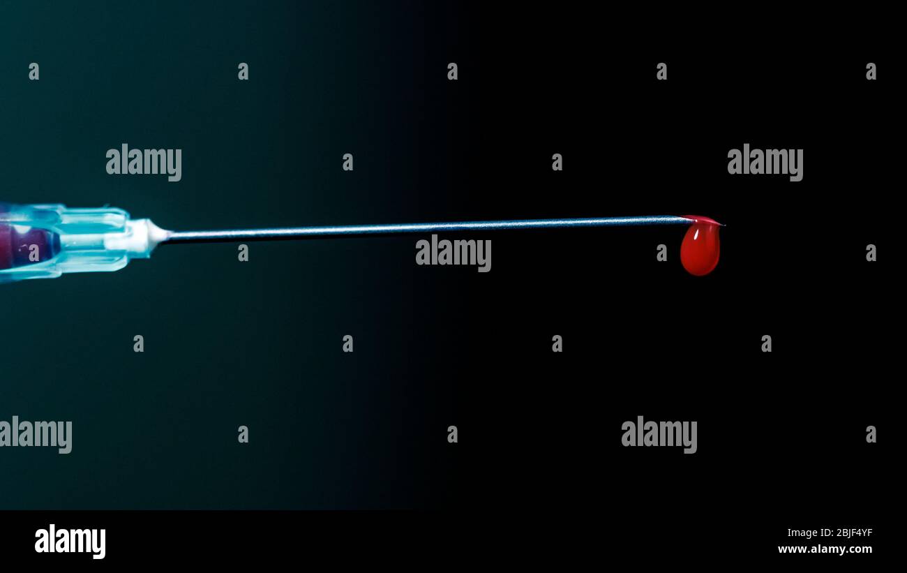 Syringe with blood isolated on dark background, closeup Stock Photo - Alamy