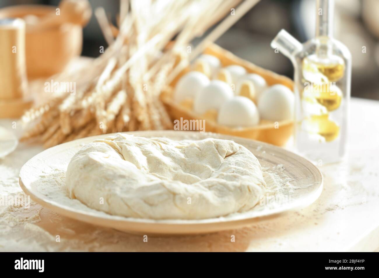 Plate with raw dough on kitchen table Stock Photo - Alamy