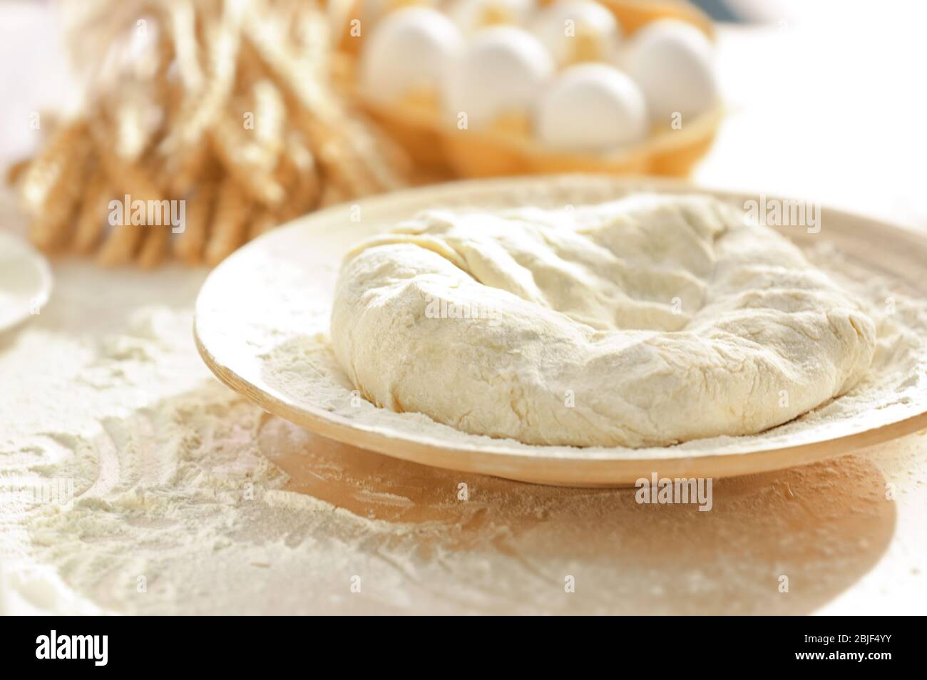Plate with raw dough on kitchen table Stock Photo - Alamy