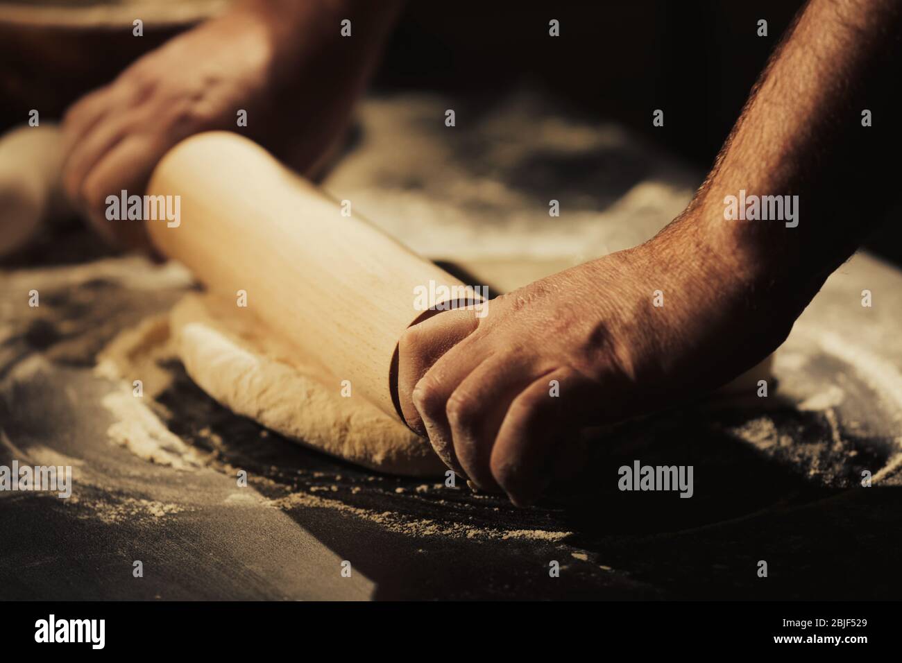 Hands of man rolling dough in kitchen, closeup Stock Photo - Alamy