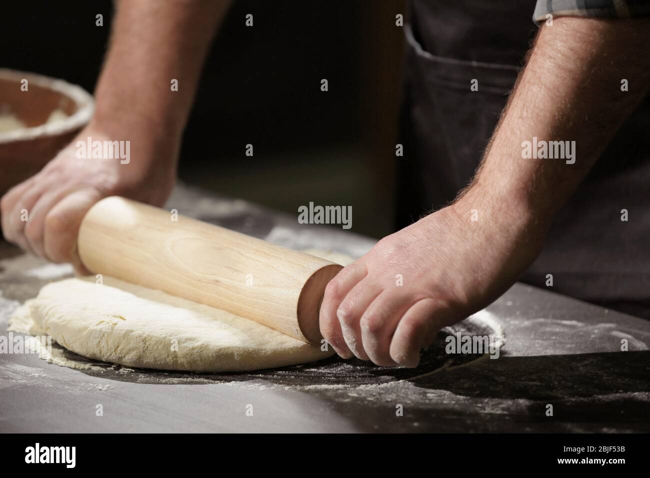 Hands of man rolling dough in kitchen Stock Photo - Alamy