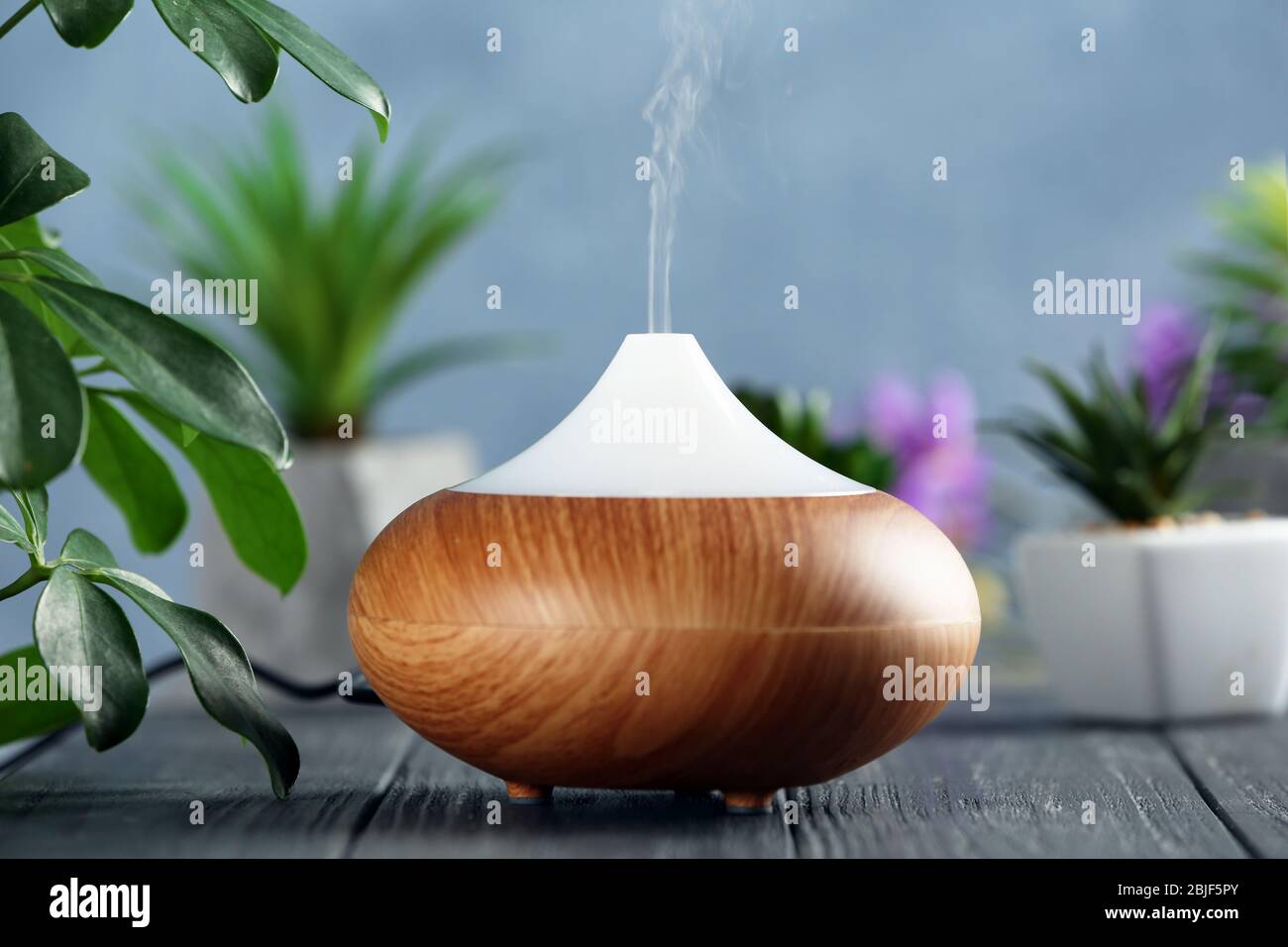 Aroma oil diffuser on wooden table Stock Photo - Alamy