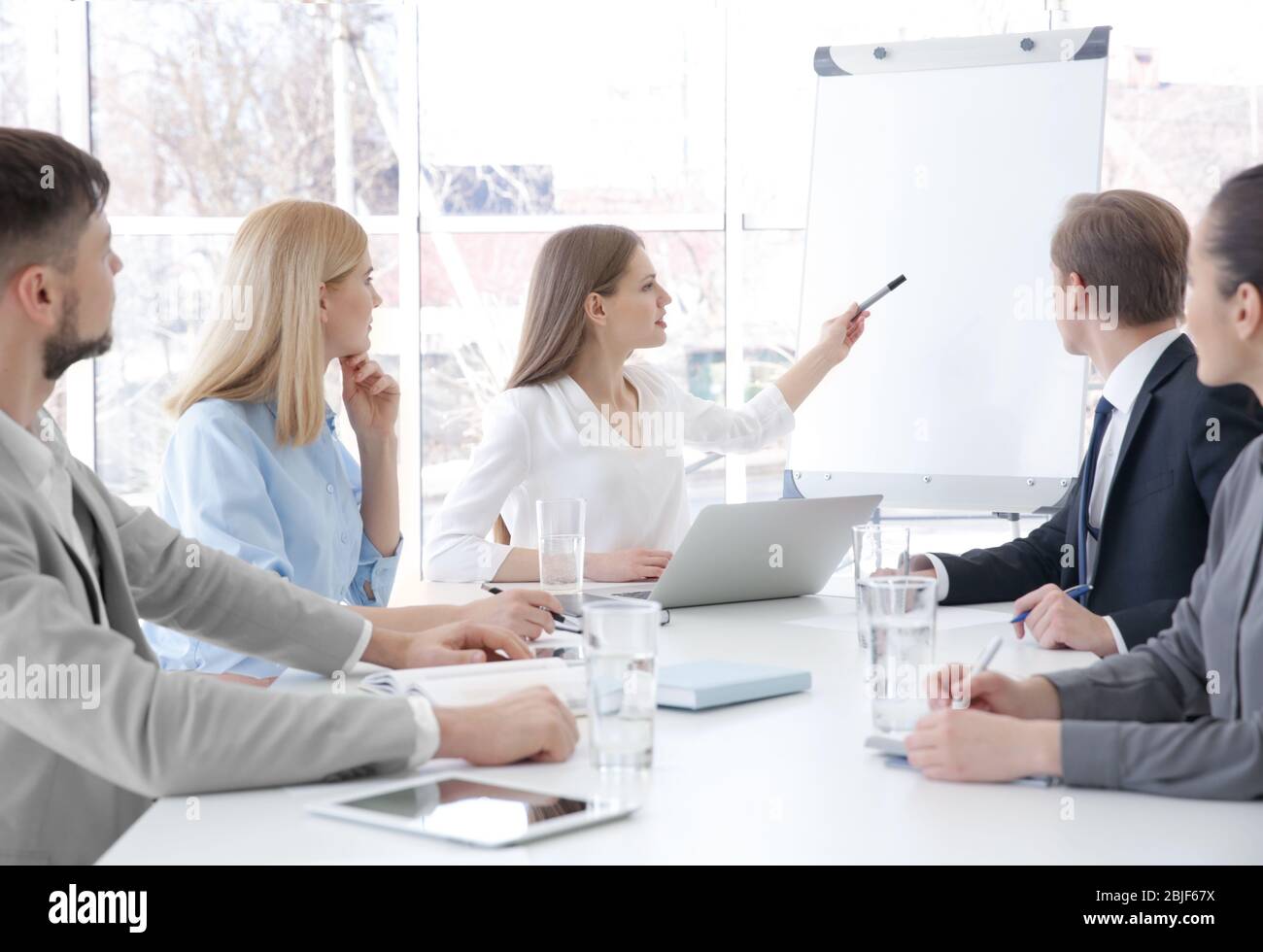 Business trainer giving presentation to group of people Stock Photo - Alamy