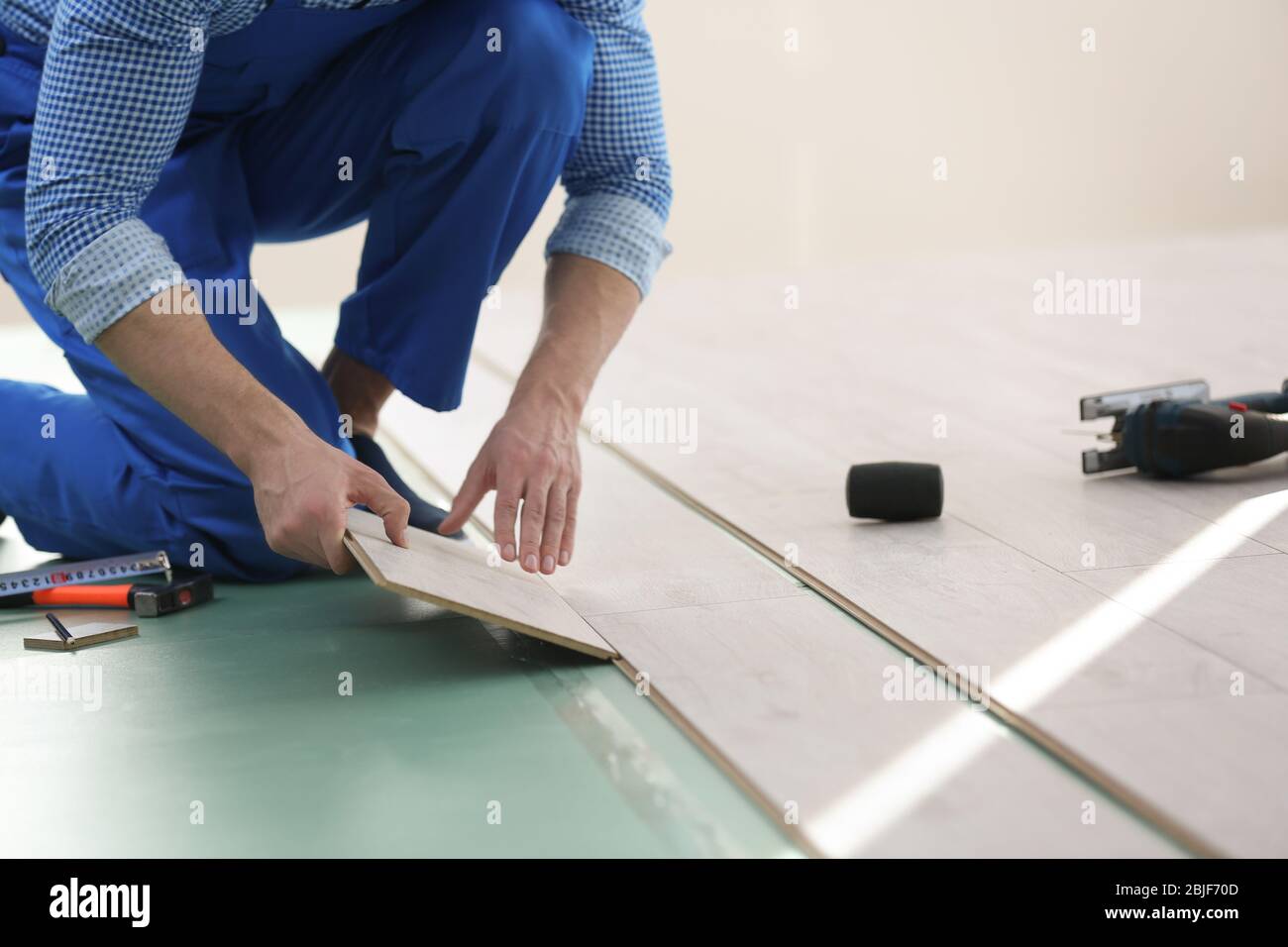 Male worker hands installing laminate flooring Stock Photo - Alamy