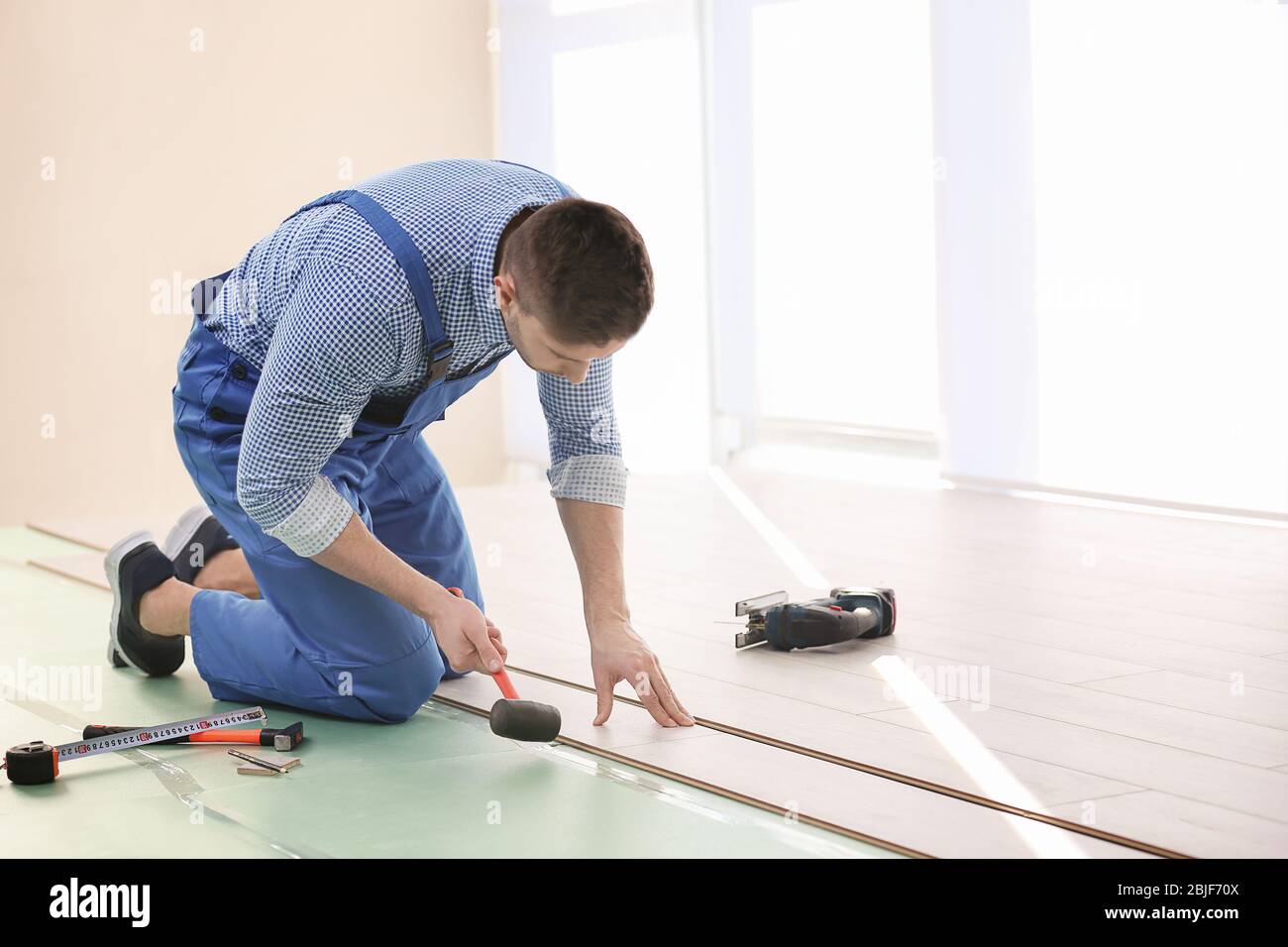 Male worker installing laminate flooring Stock Photo - Alamy