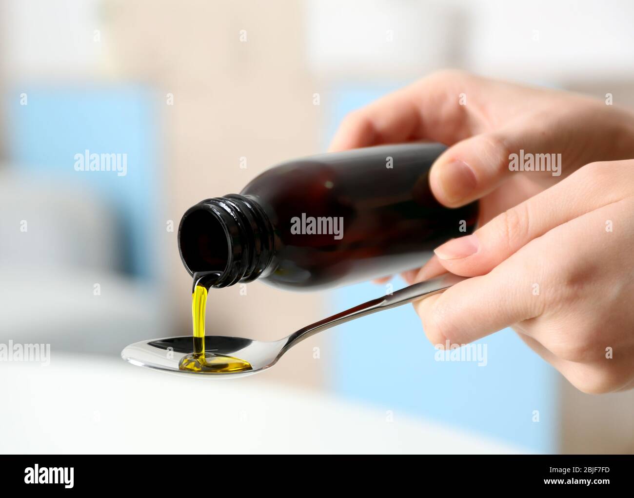 Pouring syrup in spoon, closeup Stock Photo - Alamy