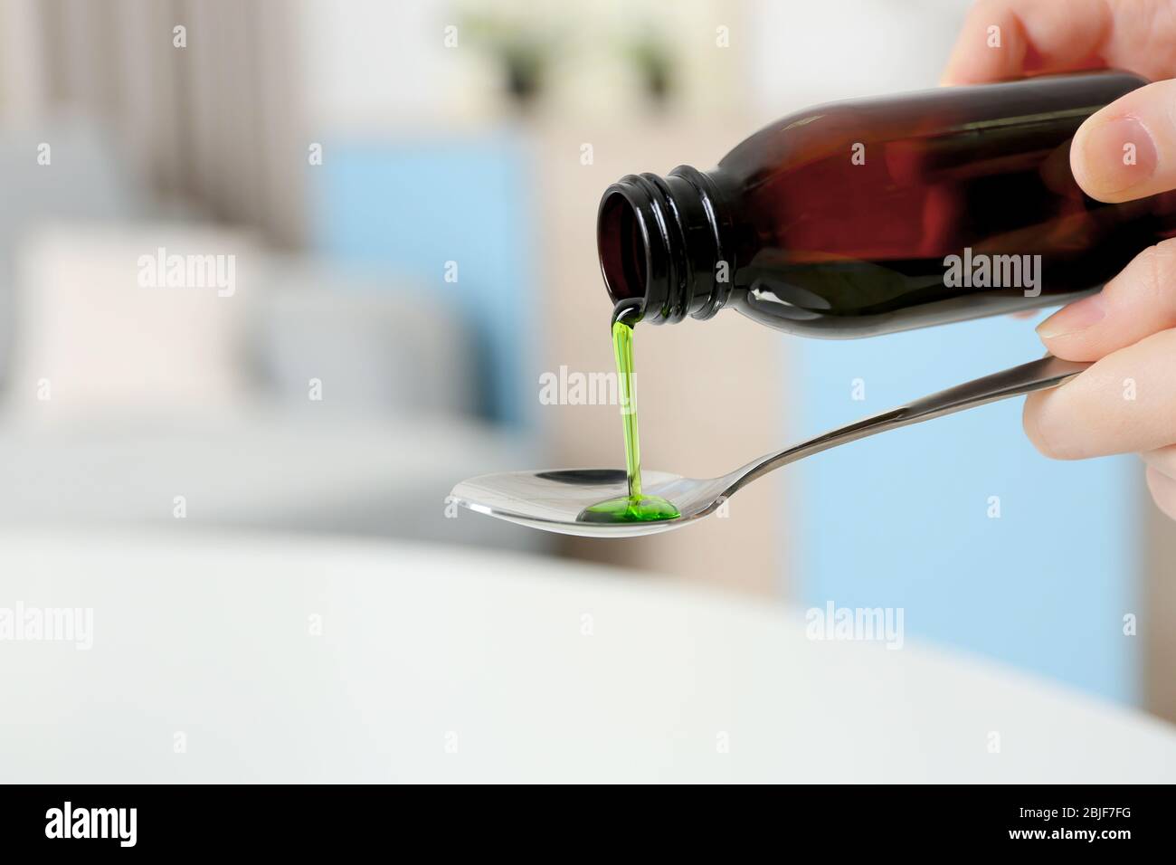 Pouring syrup in spoon, closeup Stock Photo - Alamy