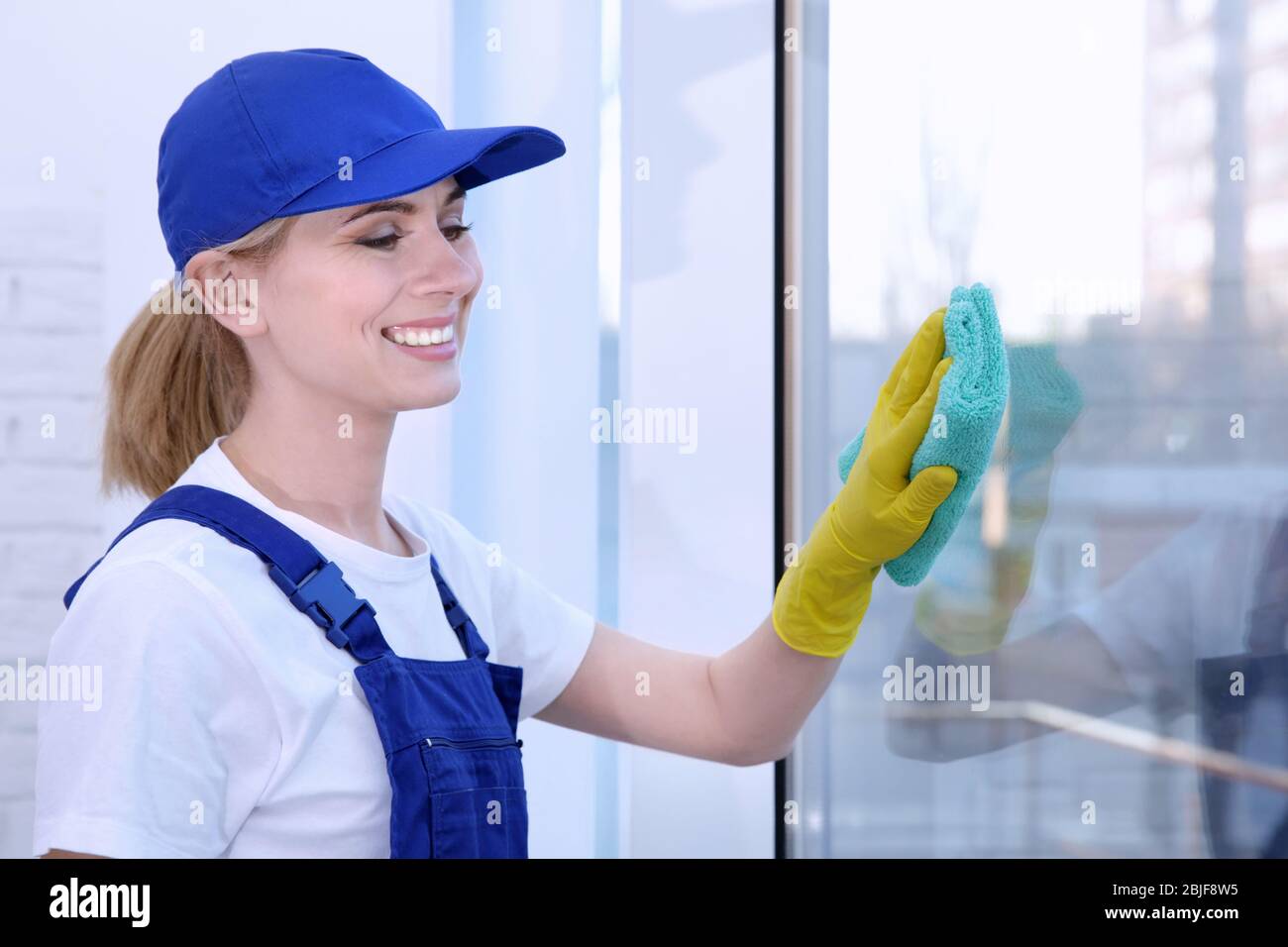 Woman cleaning window with rag indoor Stock Photo - Alamy
