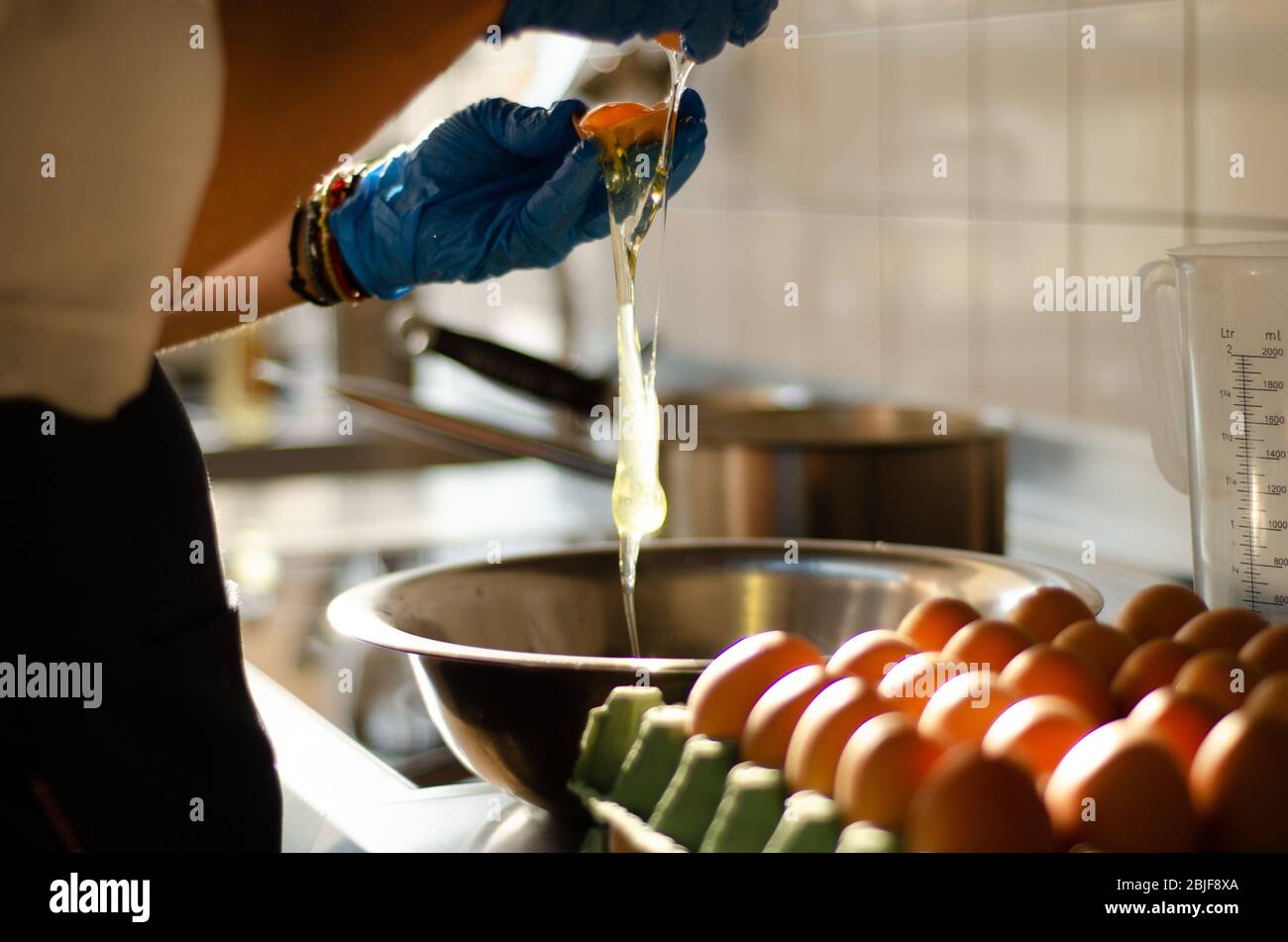 blurry chef hands crackin eggs on professional stainless steel Kitchen ...