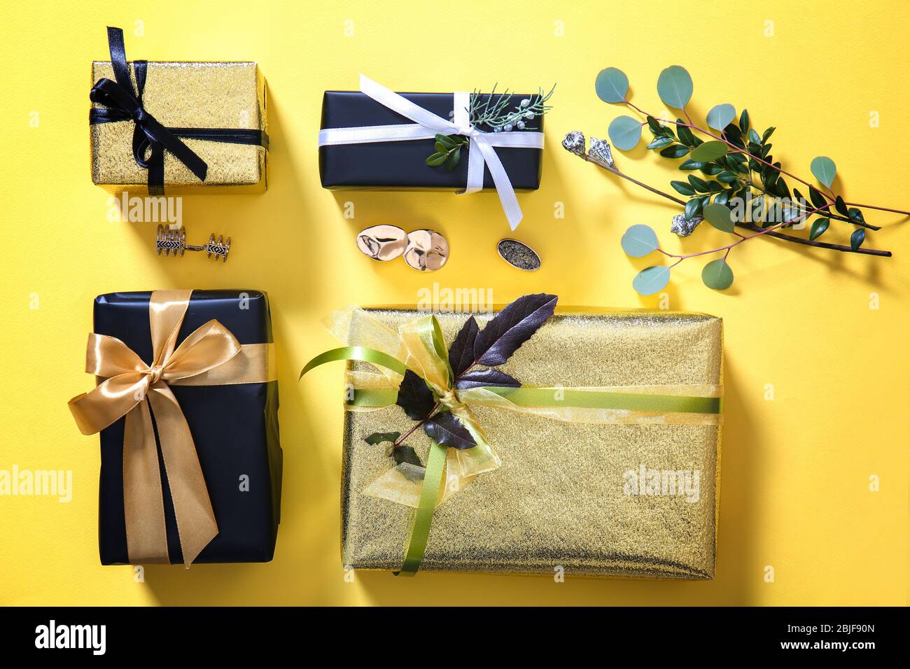 Stylish packed gift boxes and accessories on yellow background Stock ...