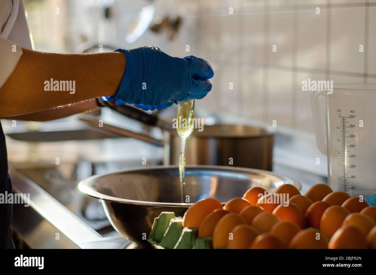 blurry chef hands crackin eggs on professional stainless steel Kitchen ...