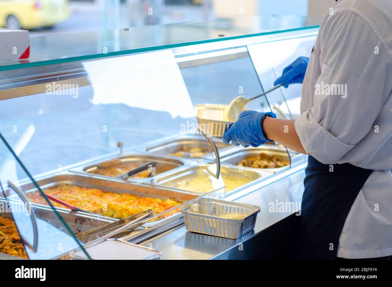 chef with blue gloves serves food in food containers Stock Photo - Alamy