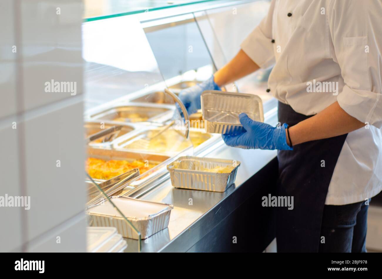 chef with blue gloves serves food in food containers Stock Photo - Alamy