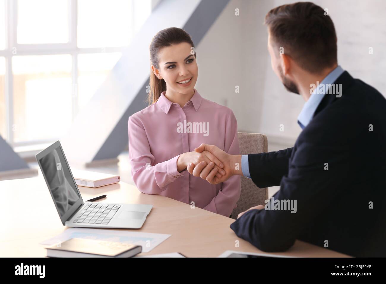 Manager and client shaking hands in office Stock Photo - Alamy
