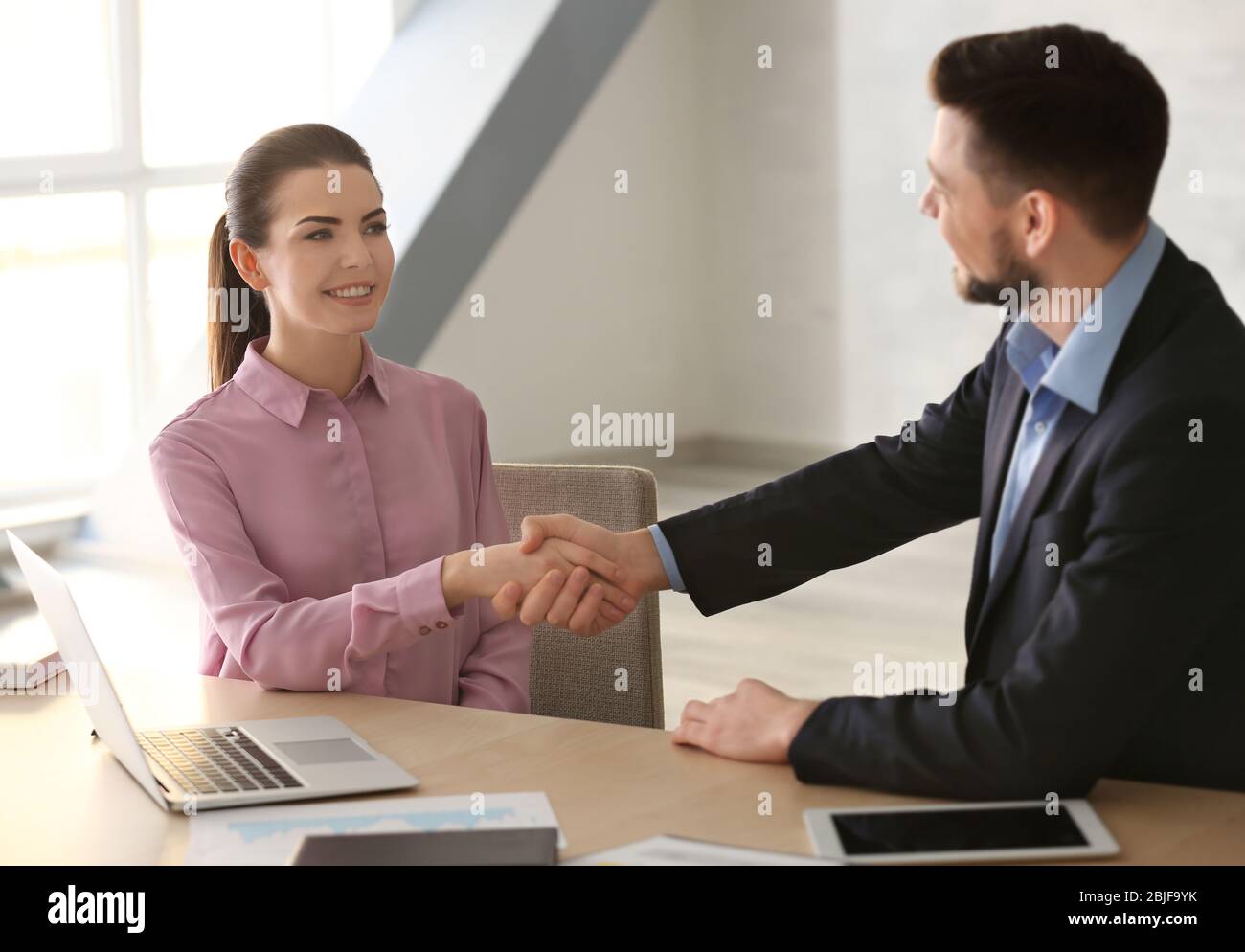 Manager and client shaking hands in office Stock Photo - Alamy
