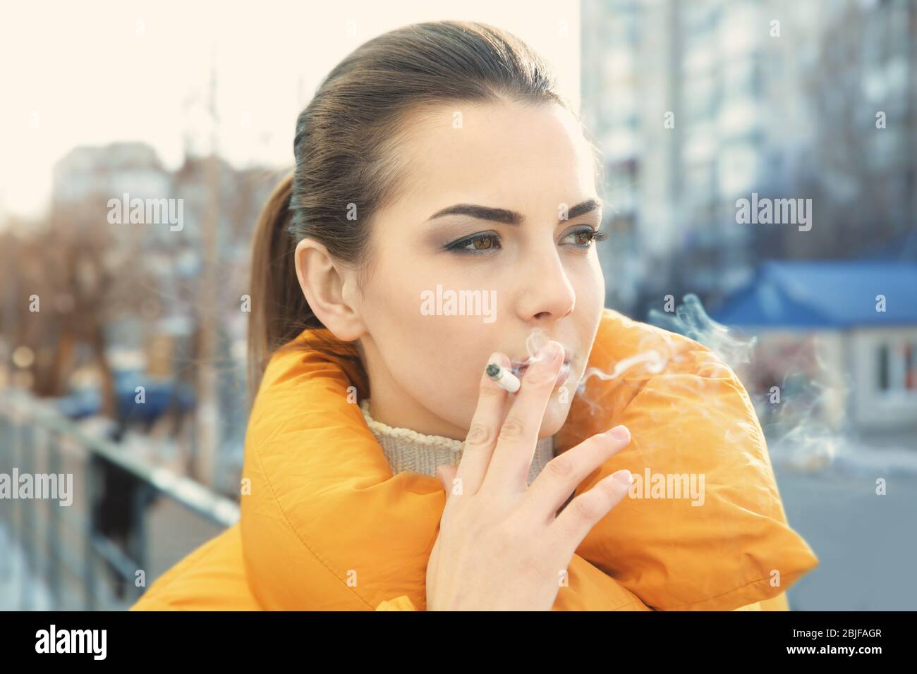 Young woman smoking cigarette, outdoor Stock Photo - Alamy
