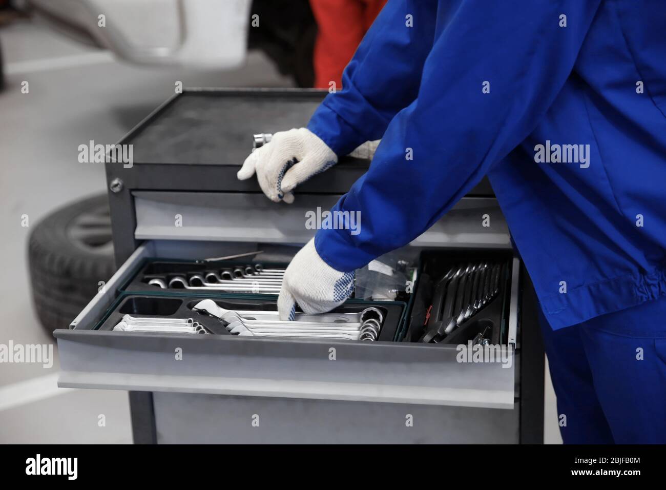Mechanic in uniform near tools box, closeup Stock Photo - Alamy