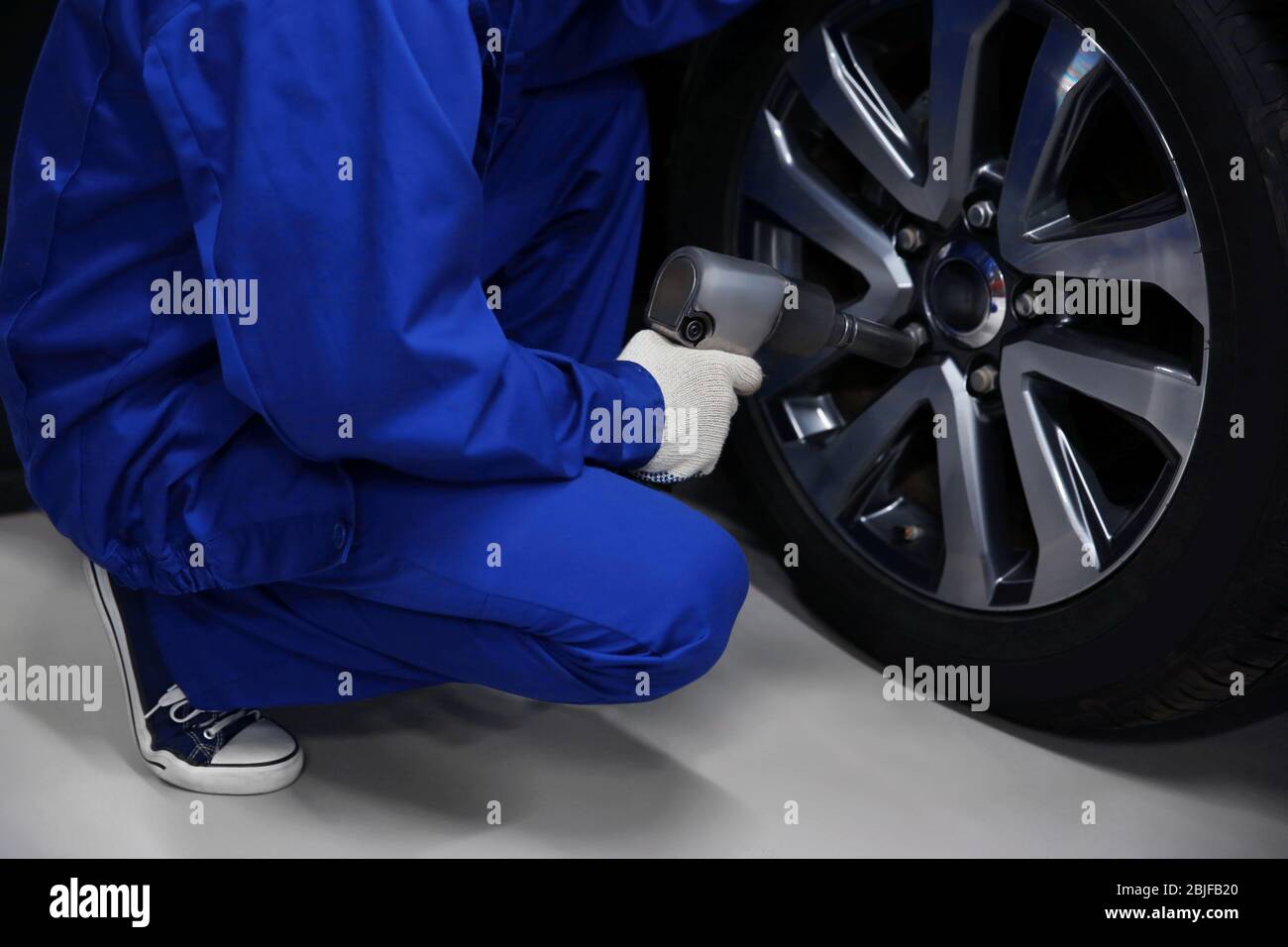 Mechanic changing wheel, closeup Stock Photo - Alamy