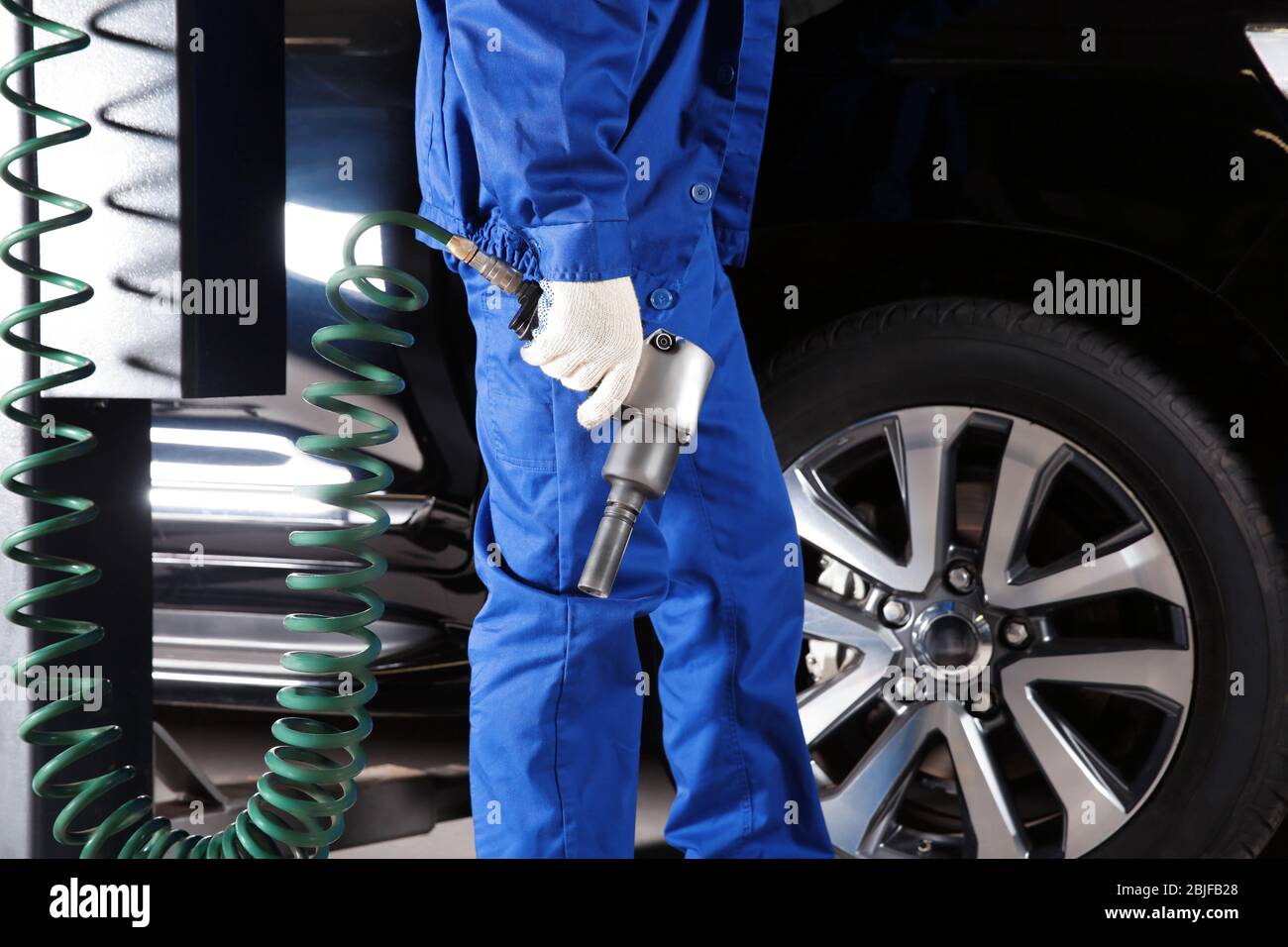 Mechanic changing wheel in car service, closeup Stock Photo - Alamy