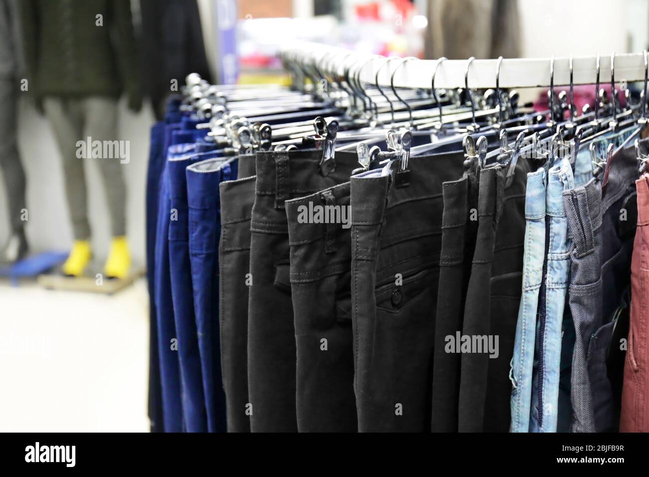 Rack with pants in modern shop Stock Photo - Alamy