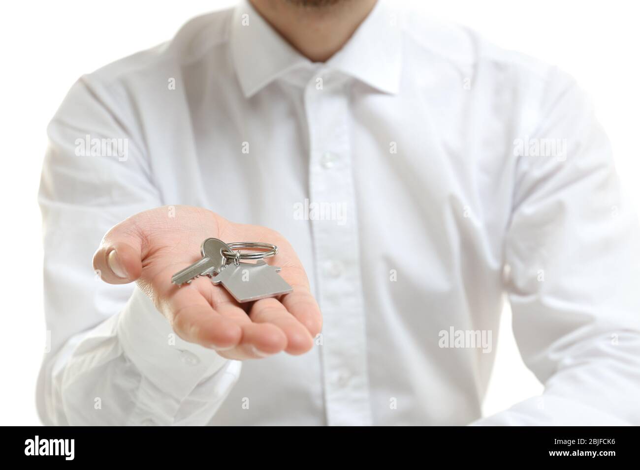 Man holding house key in hand on white background Stock Photo - Alamy