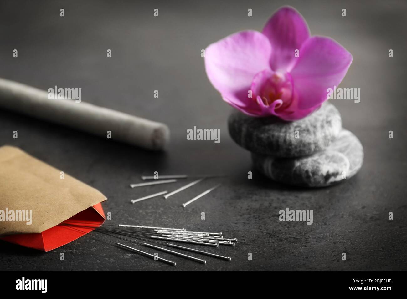 Composition of acupuncture needles and spa tools on grey background ...