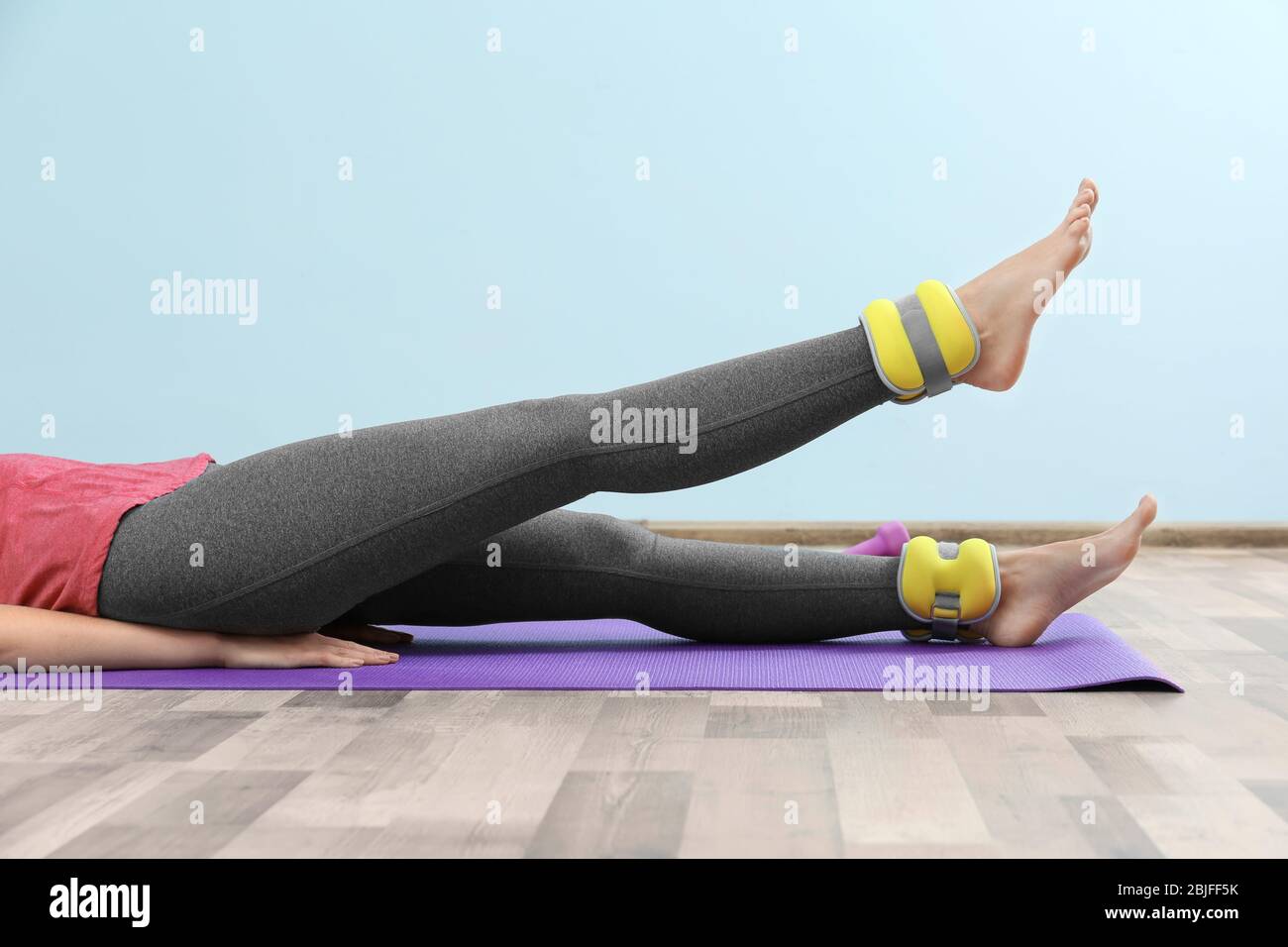 Woman training with weights on legs in gym Stock Photo - Alamy