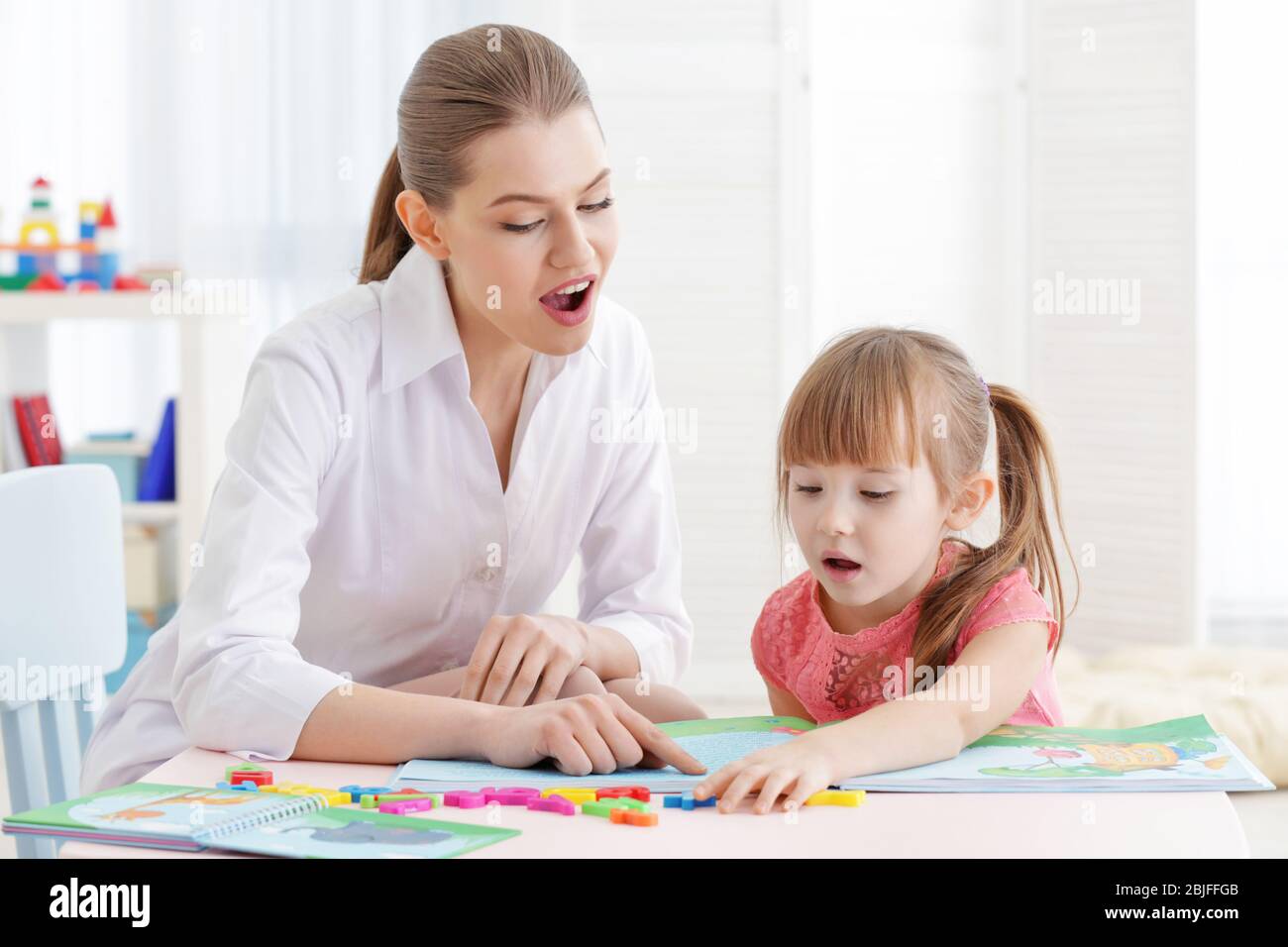 Cute little girl at speech therapist office Stock Photo - Alamy