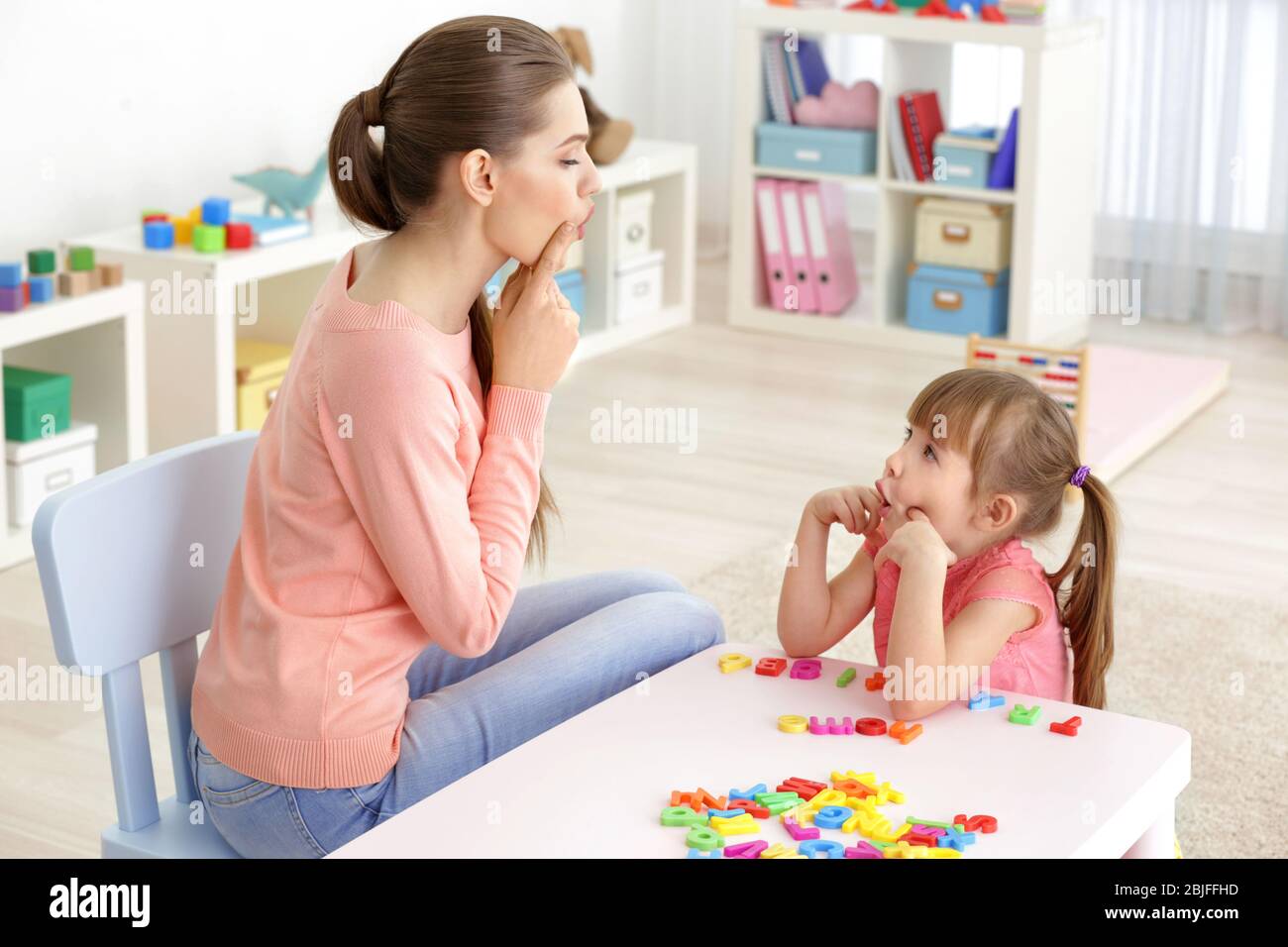Cute little girl at speech therapist office Stock Photo - Alamy