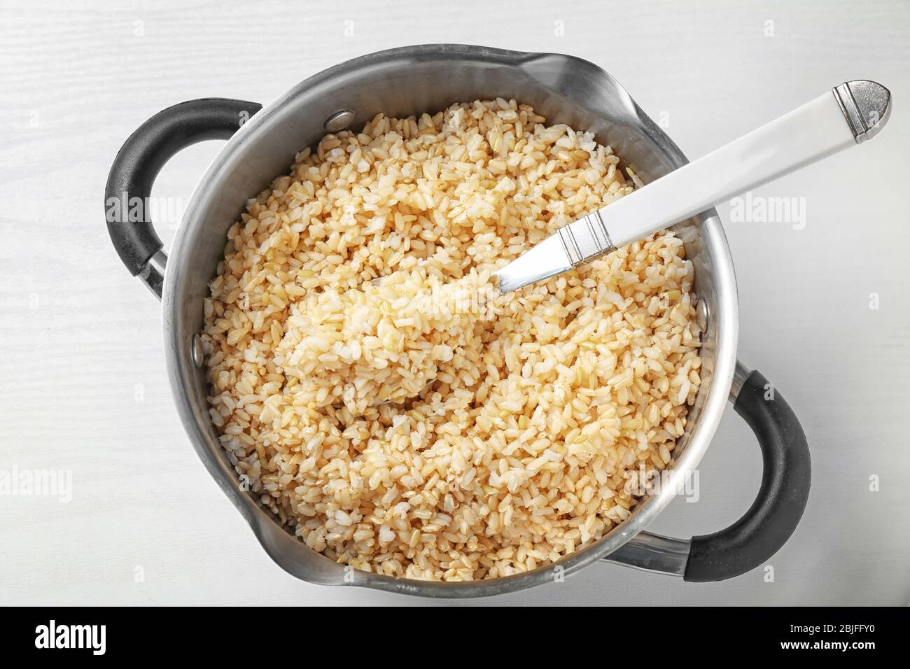 Pan with boiled brown rice on white background Stock Photo - Alamy