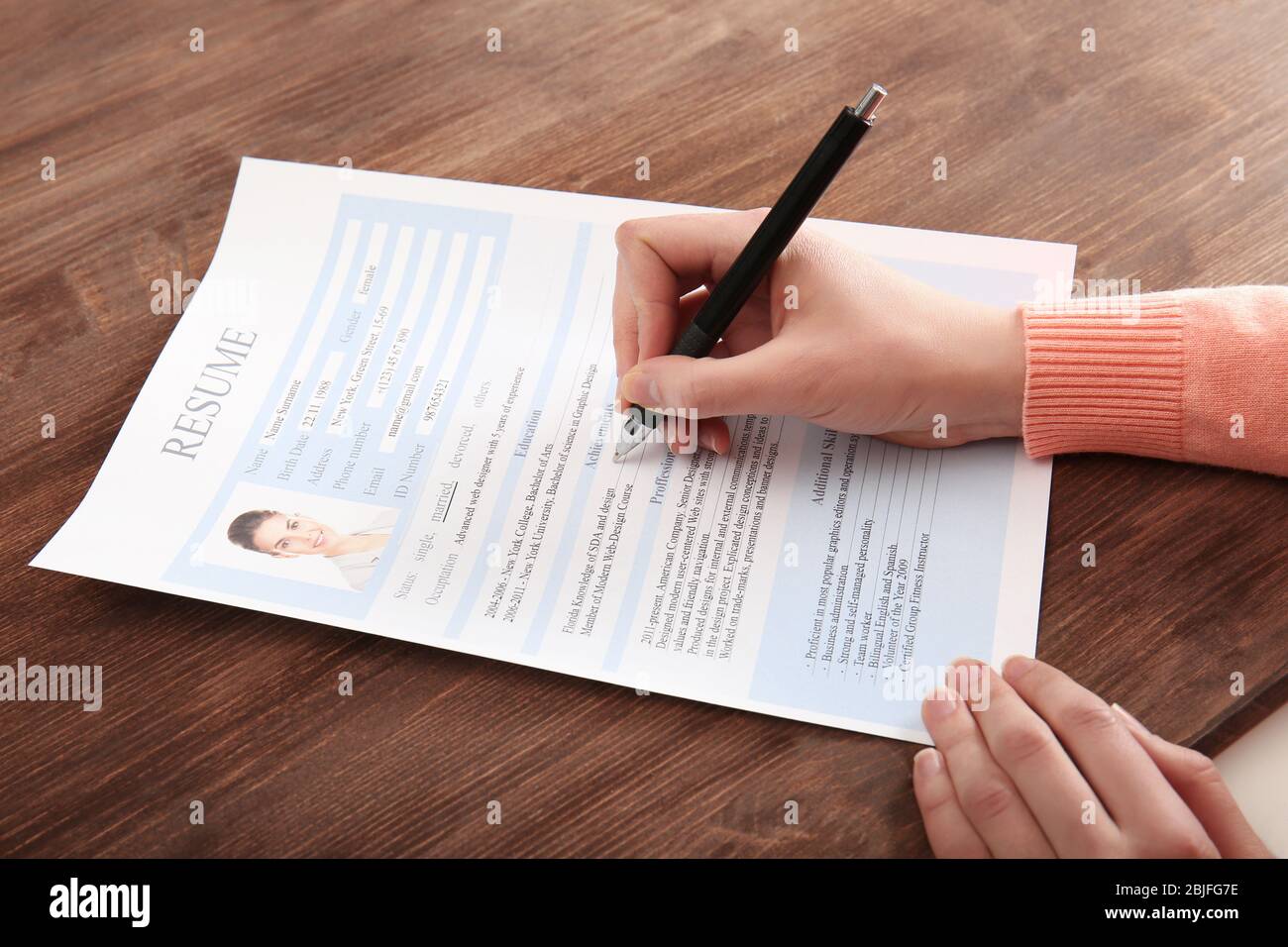 Woman filling in resume form on table. Job interview concept Stock ...