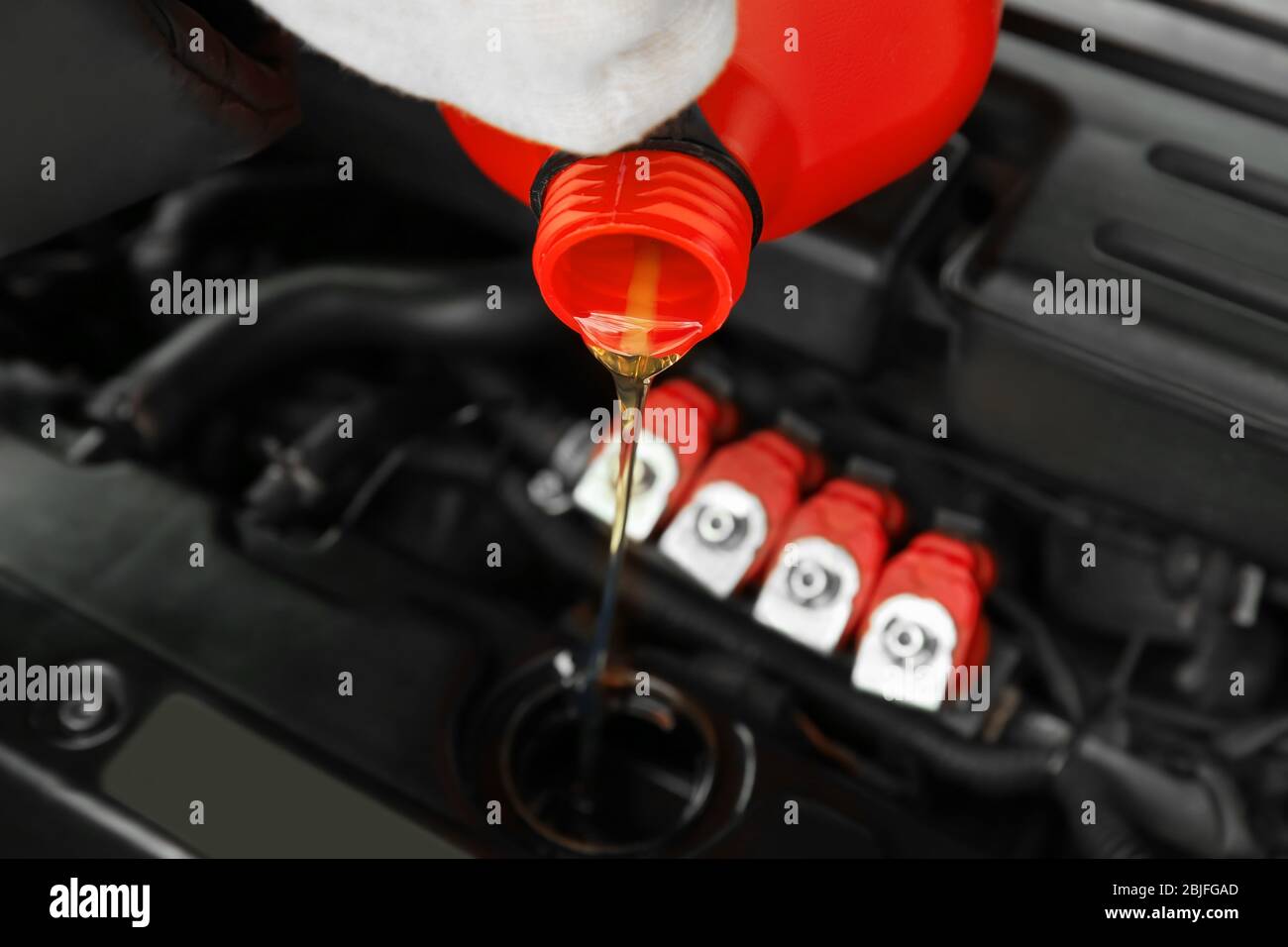 Engine oil pouring from canister, closeup Stock Photo - Alamy