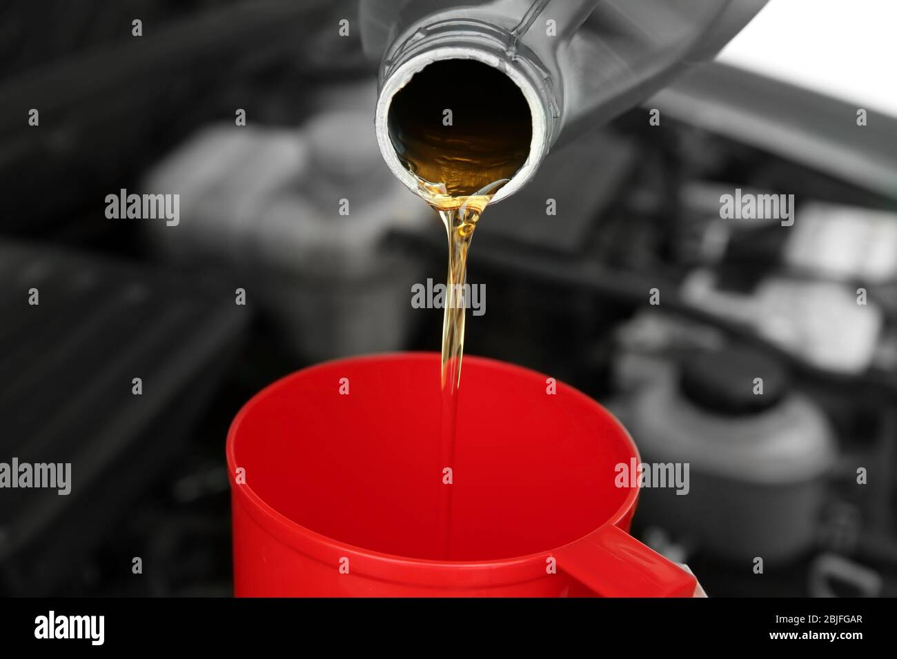 Engine oil pouring from canister, closeup Stock Photo - Alamy