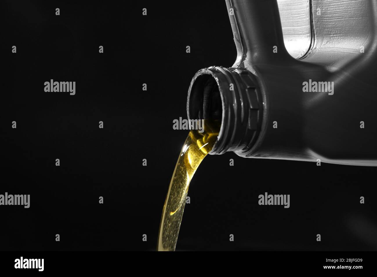 Engine oil pouring from canister on dark background, closeup Stock ...