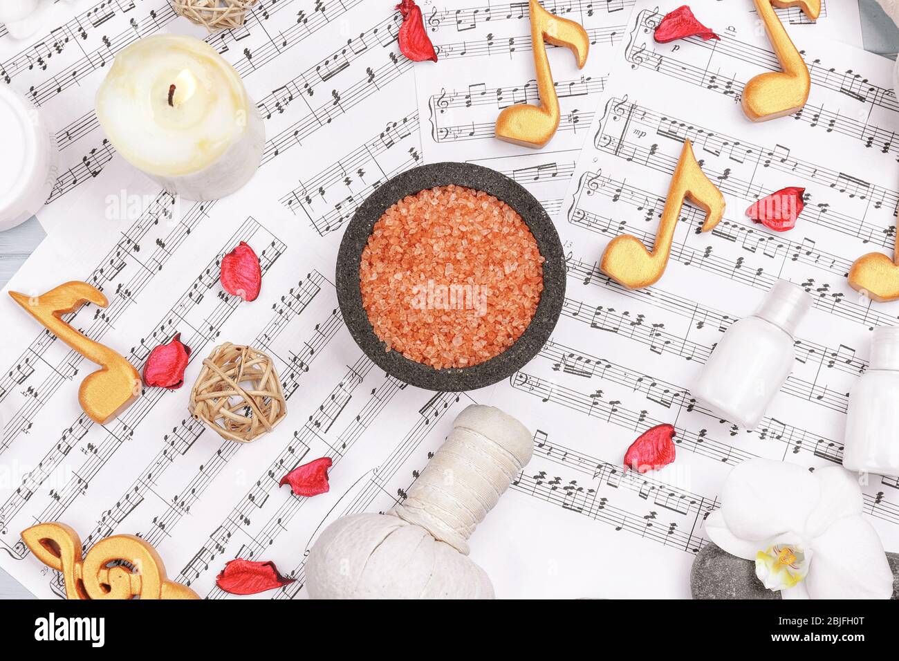 Beautiful composition of spa accessories on musical notes background ...