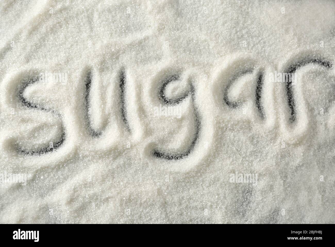 Written word SUGAR on dark background Stock Photo - Alamy