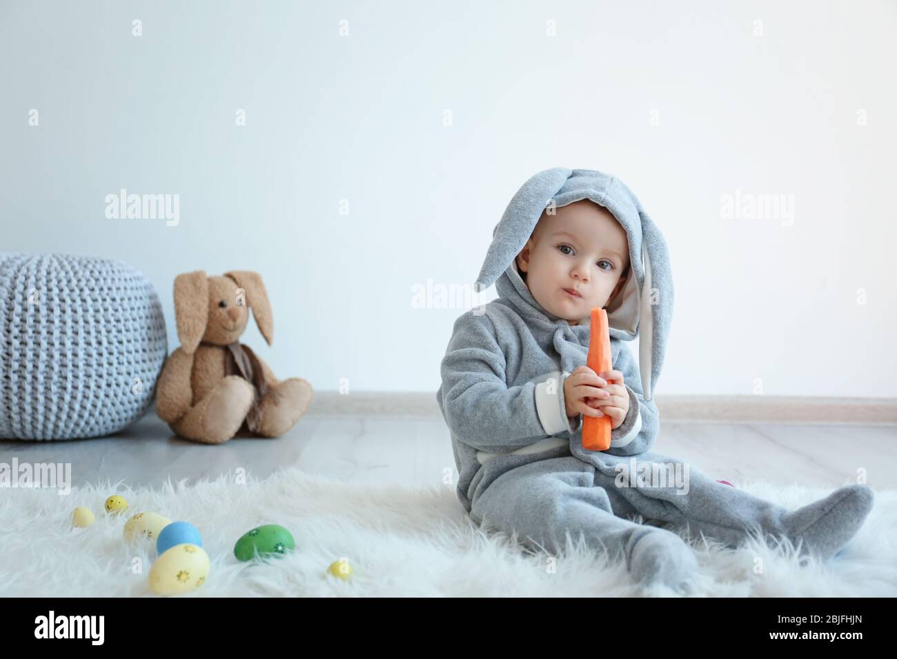 Cute little baby in bunny costume sitting on furry rug Stock Photo - Alamy