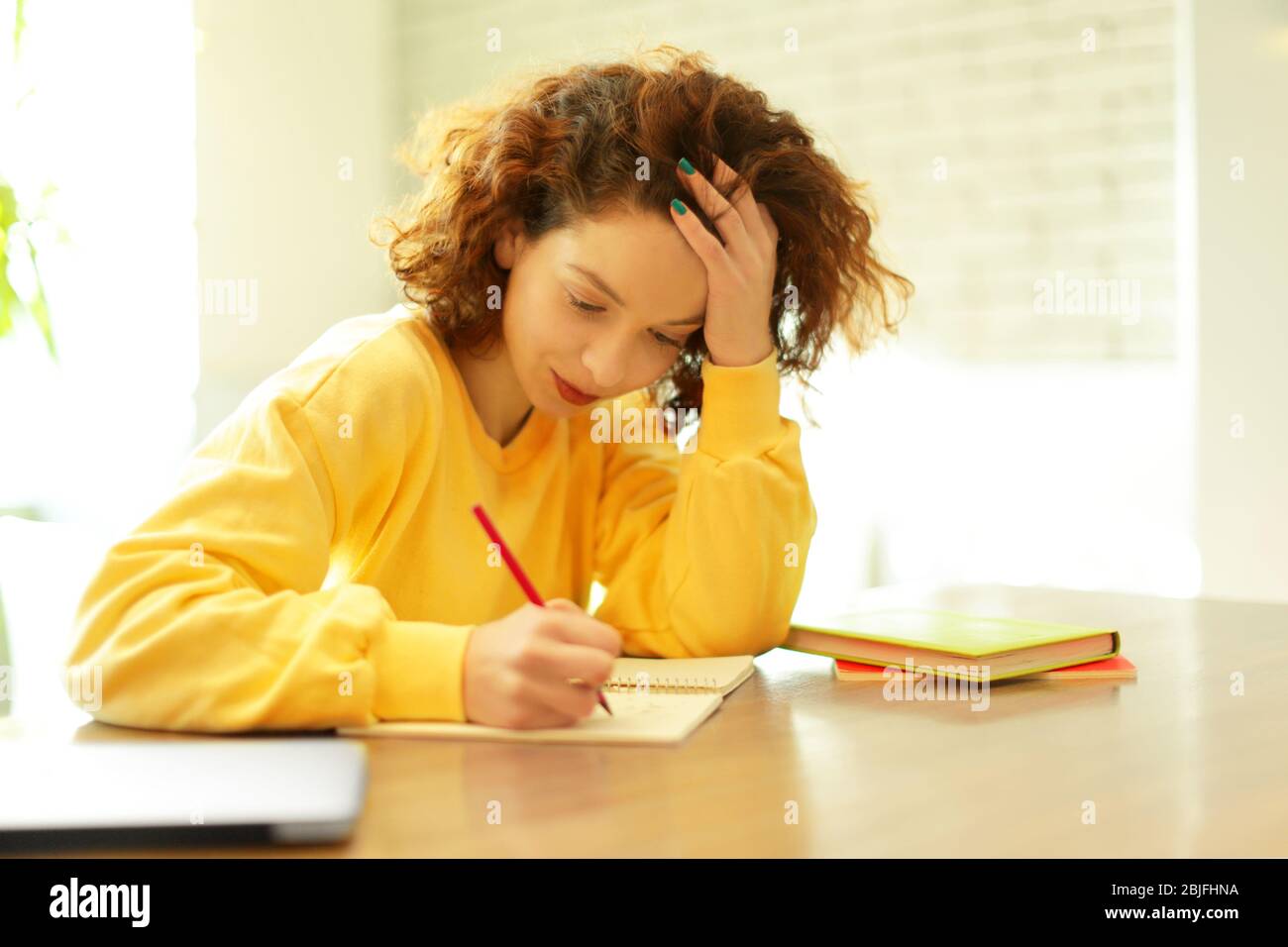 Beautiful girl writing in notebook in cafe Stock Photo - Alamy