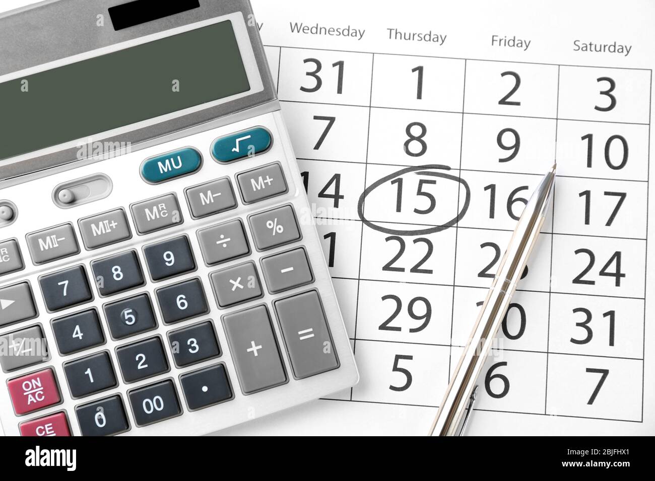 Calculator with pen on calendar. Tax concept Stock Photo - Alamy