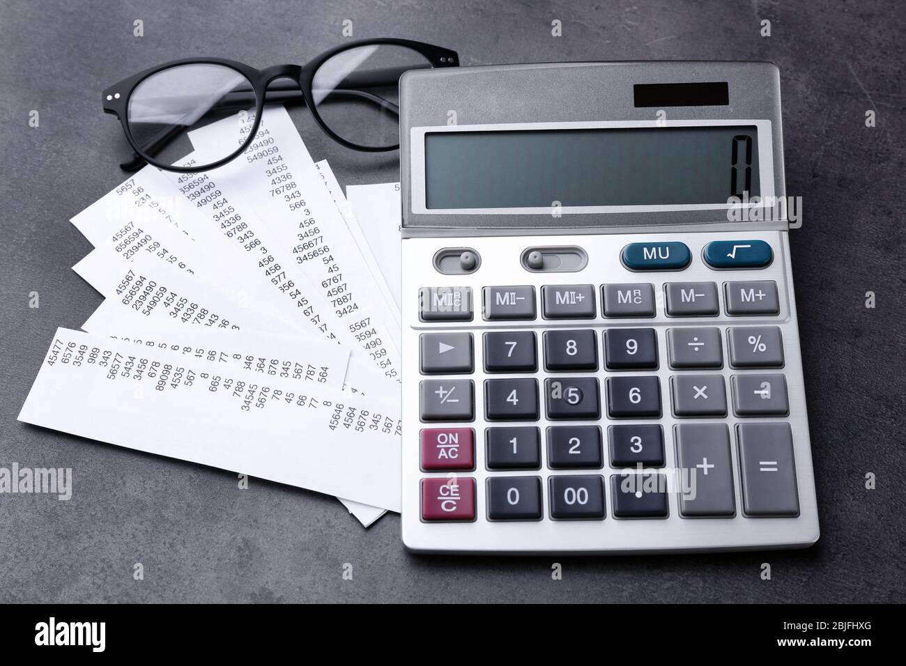 Calculator with bills on gray background. Tax concept Stock Photo - Alamy