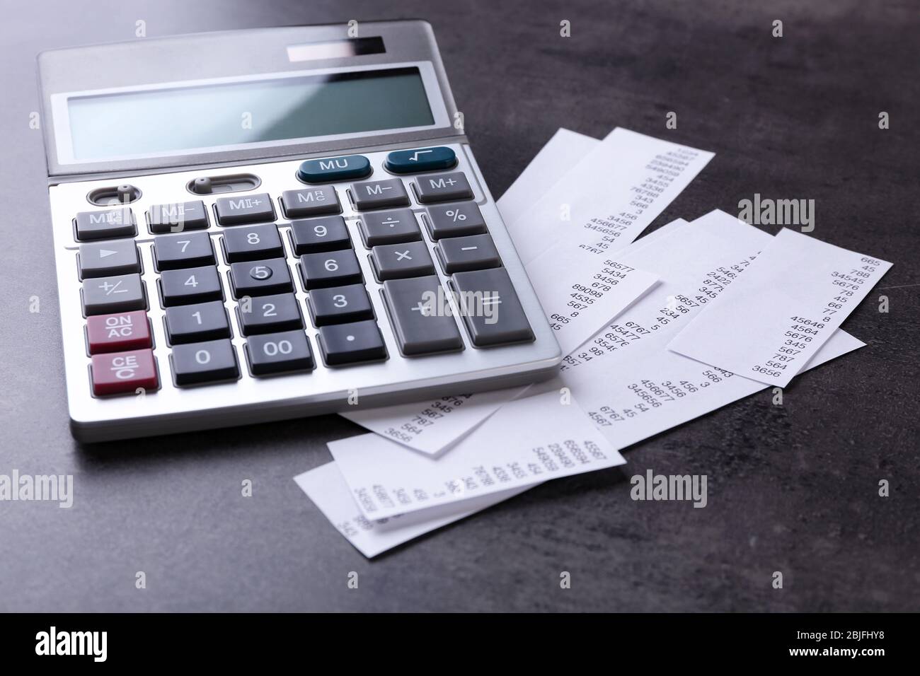 Calculator with bills on gray background. Tax concept Stock Photo - Alamy